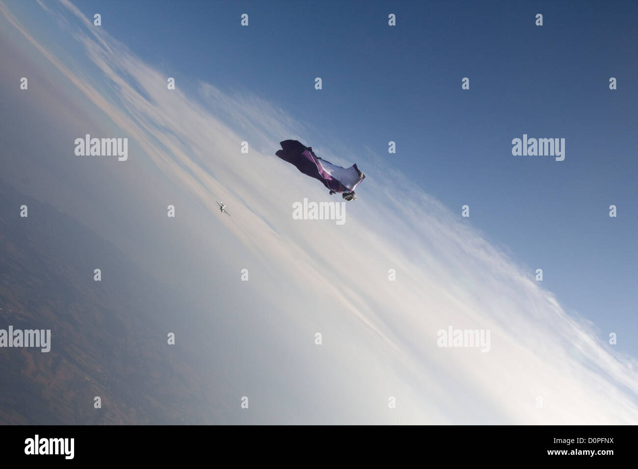 Man with wings is flying free in the cloudy sky. This wingsuit jumper ...
