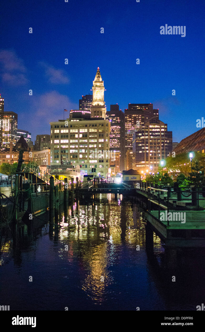 View of downtown Boston at night from Long Wharf. In the center of ...