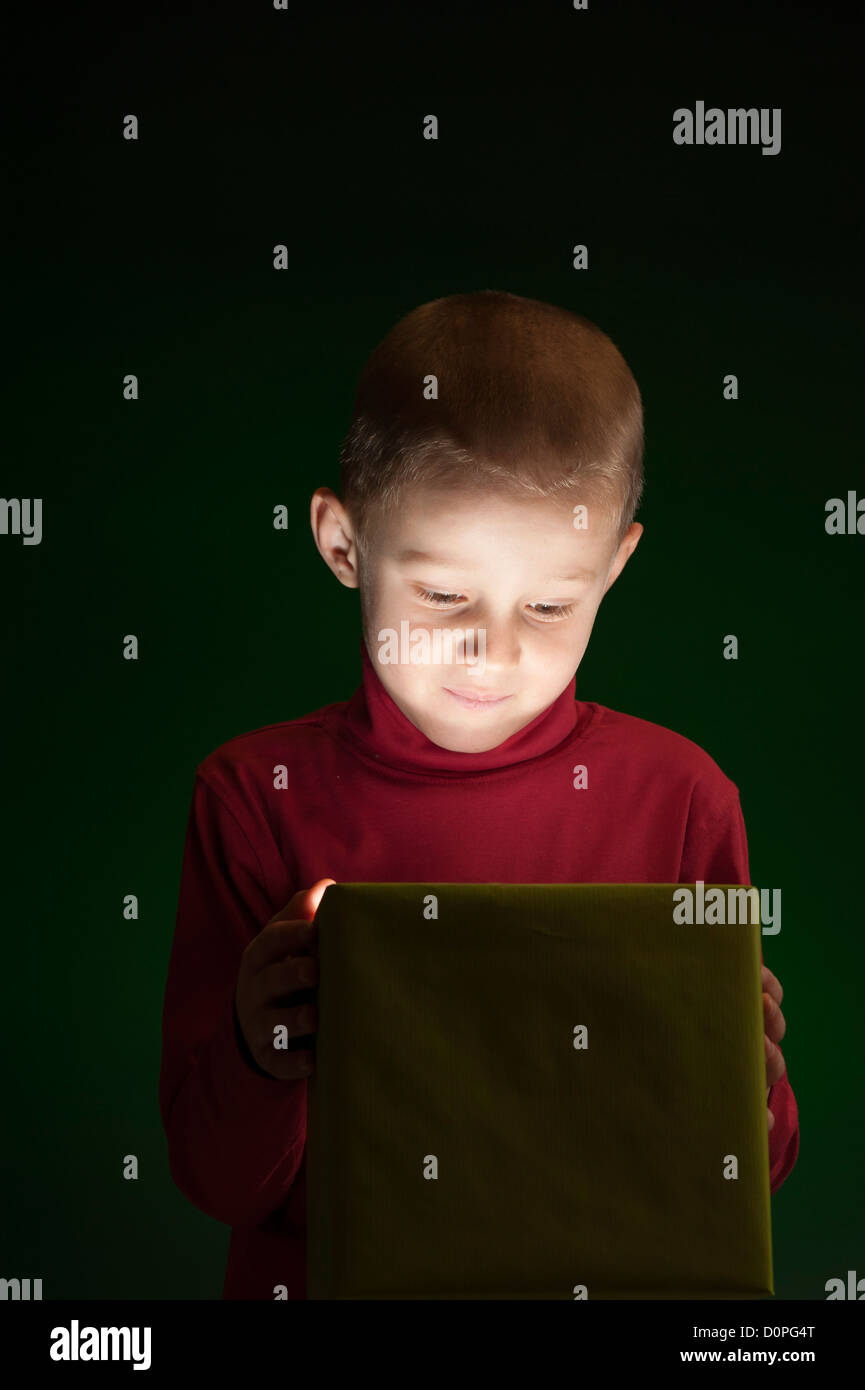 boy with present, light coming out of the box Stock Photo - Alamy