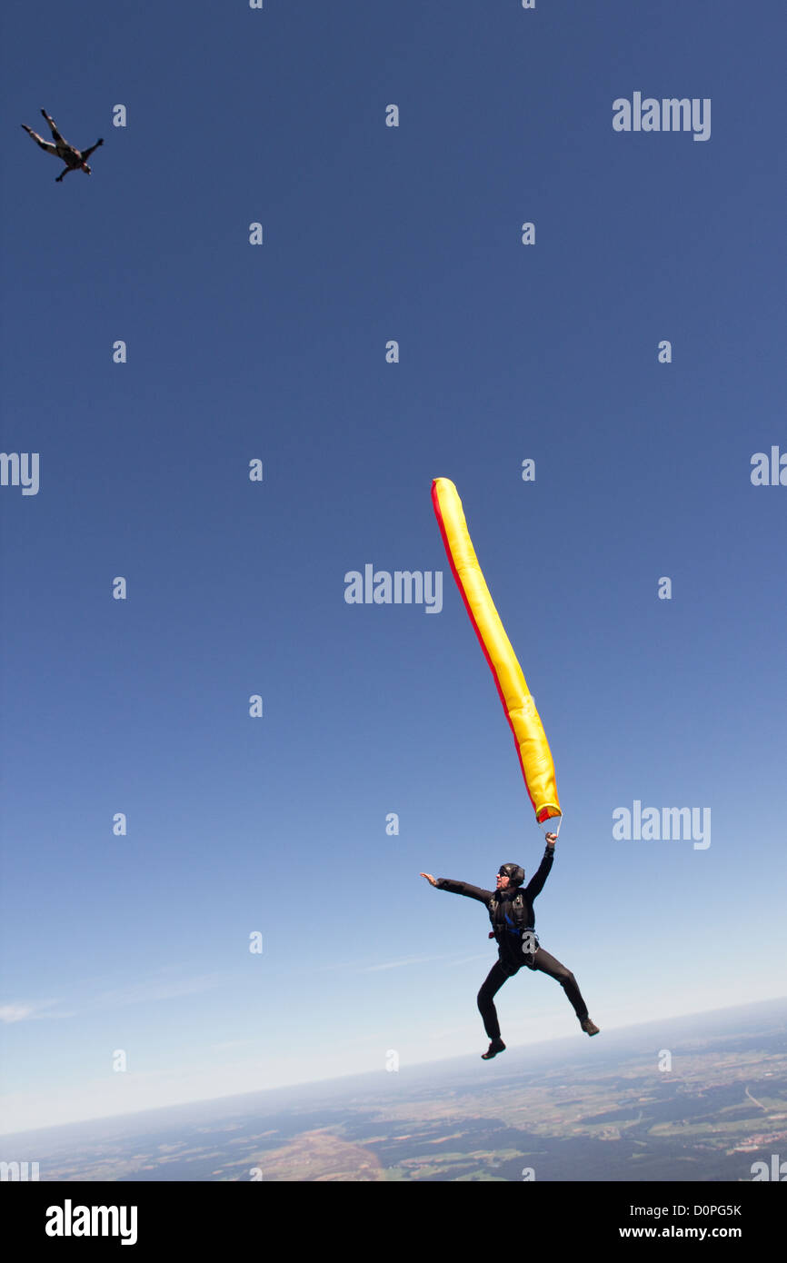 Skydiver is holding a colorful air tube in his hand and another diver ...