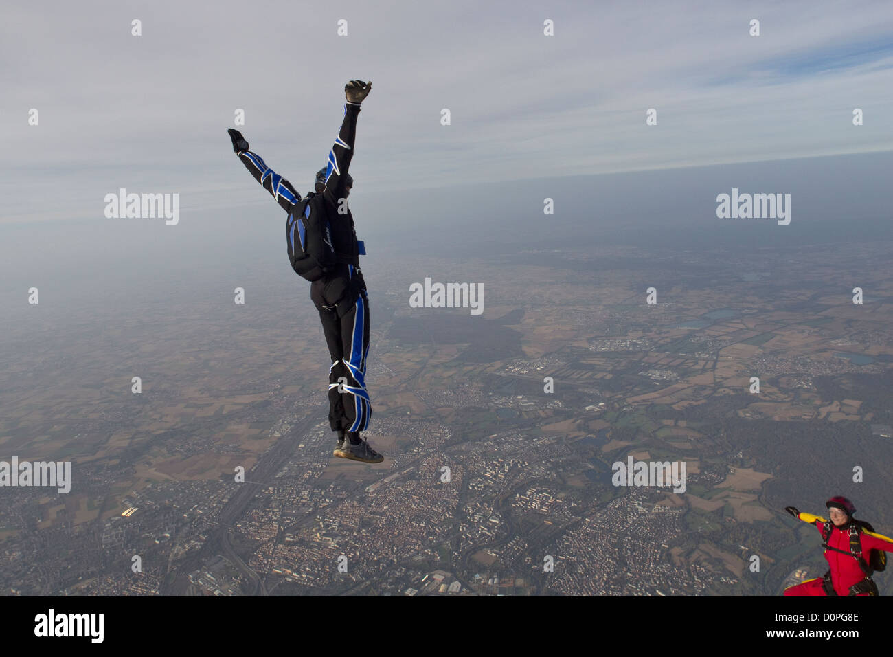 Skydiver team is training in the sky together. The woman is sit flying ...