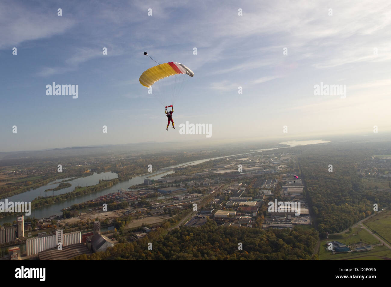 Skydiver under canopy is flying over big city and is looking out for a ...