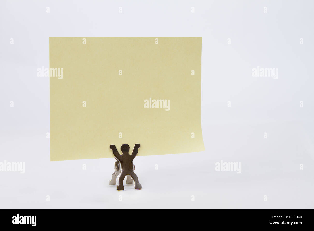 Yellow post-it on a metal support against white background Stock Photo ...