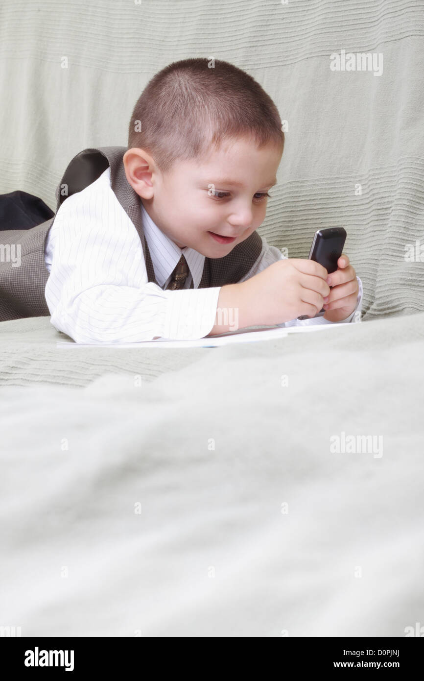 Little boy looking at cellphone Stock Photo - Alamy