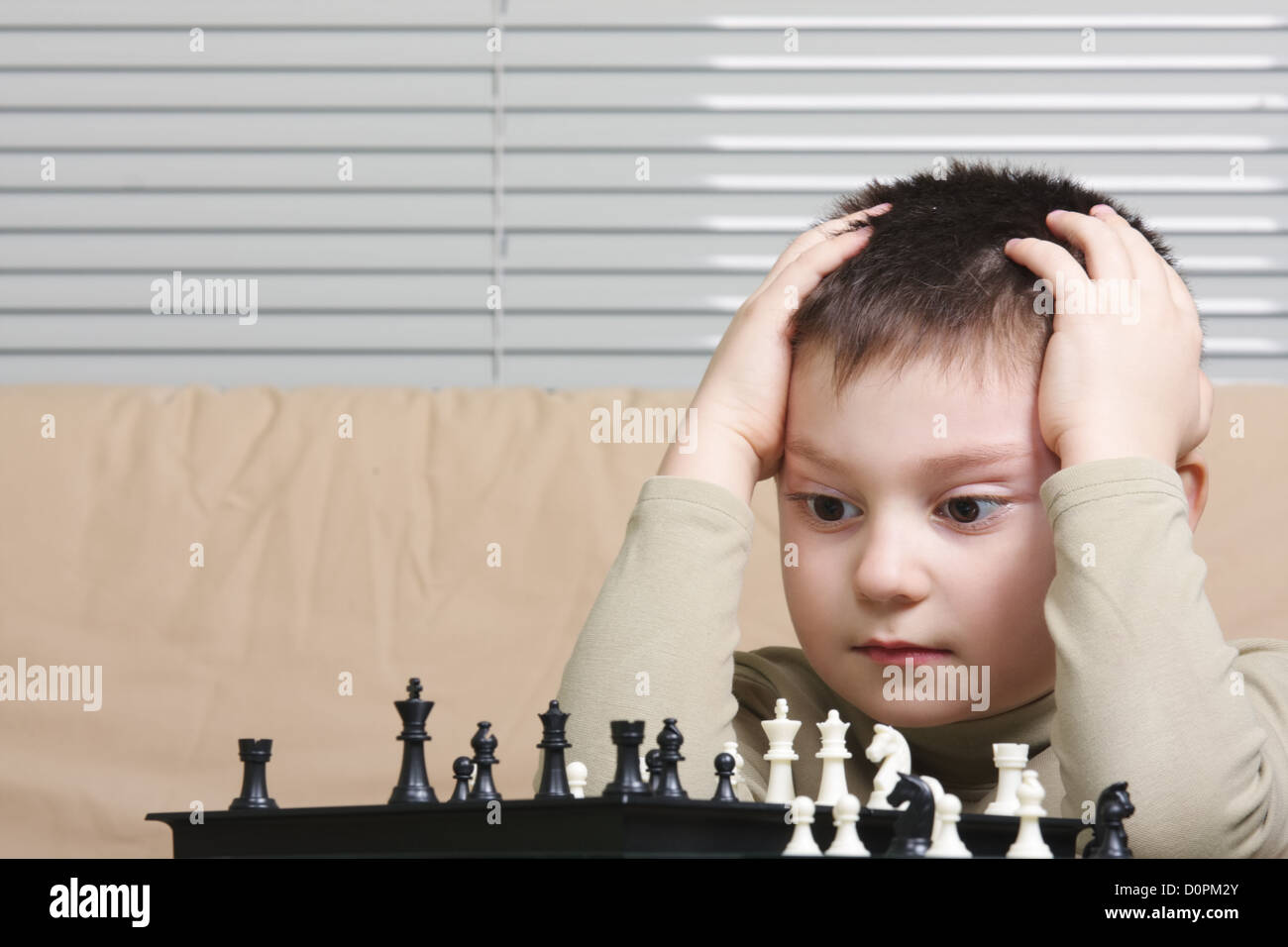 Little chess player embracing head Stock Photo - Alamy