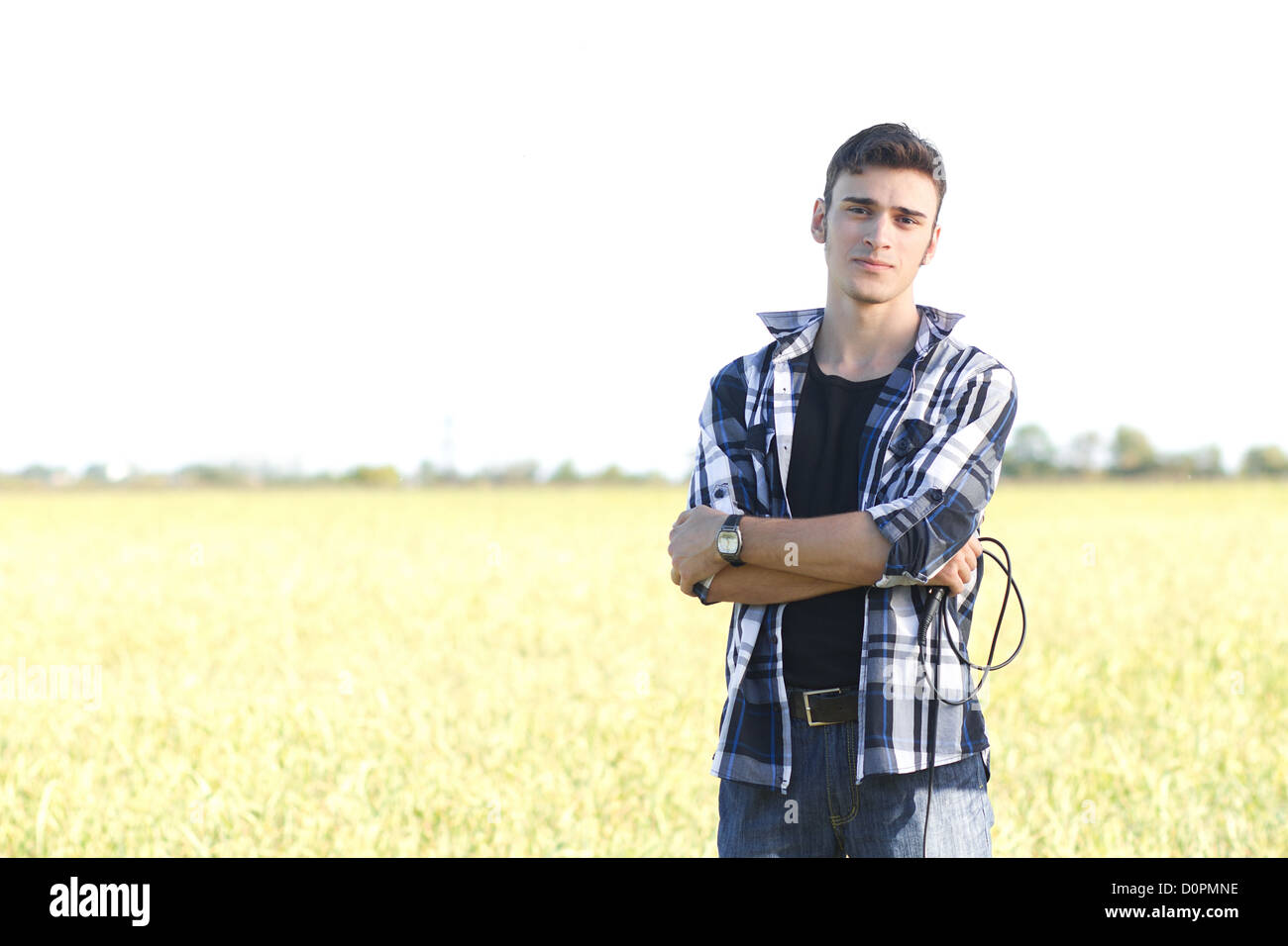 Young rock singer posing with microphone outdoors at bright summer day ...