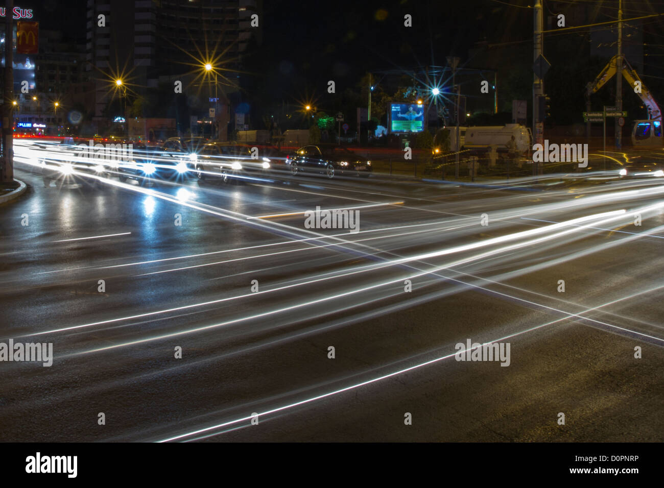 Cars passing by in a crossroad by night Stock Photo - Alamy