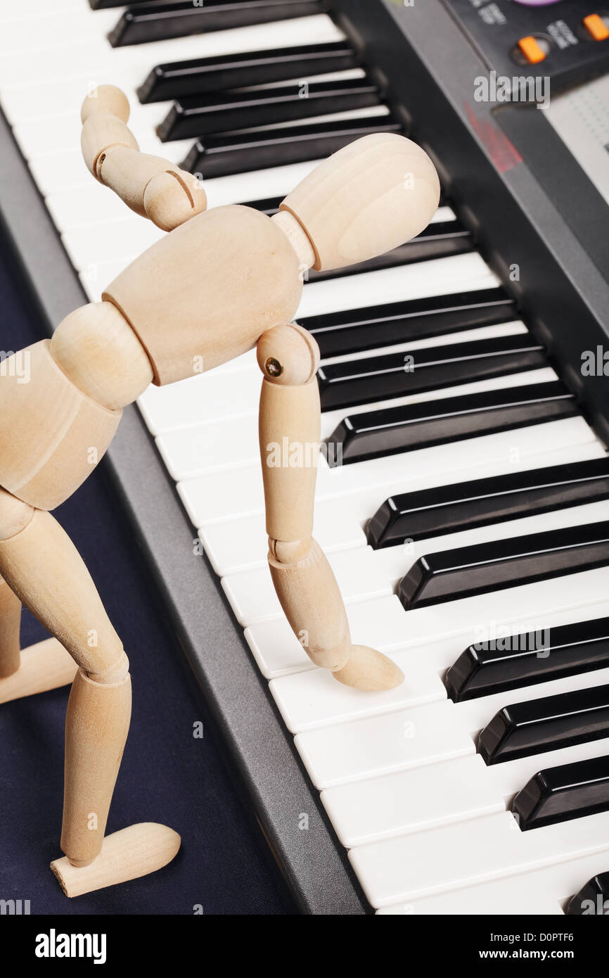Wooden doll playing piano Stock Photo - Alamy