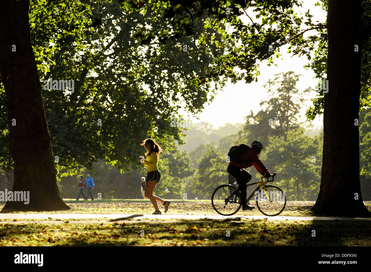 A young girl jogs past a man cycling in the opposite direction, Hyde ...