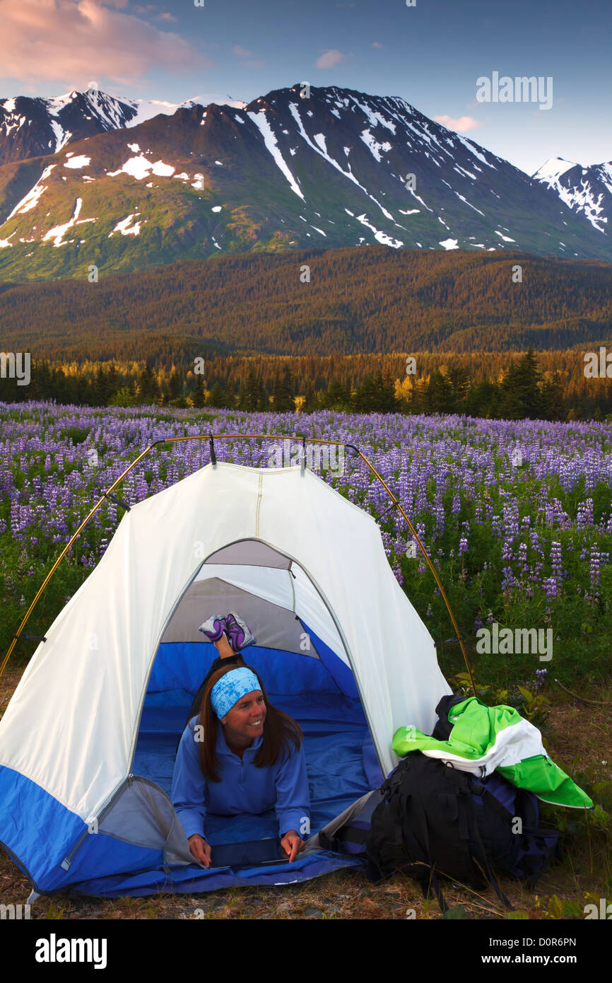 Reading an ipad while camping in the Chugach National Forest, Alaska ...