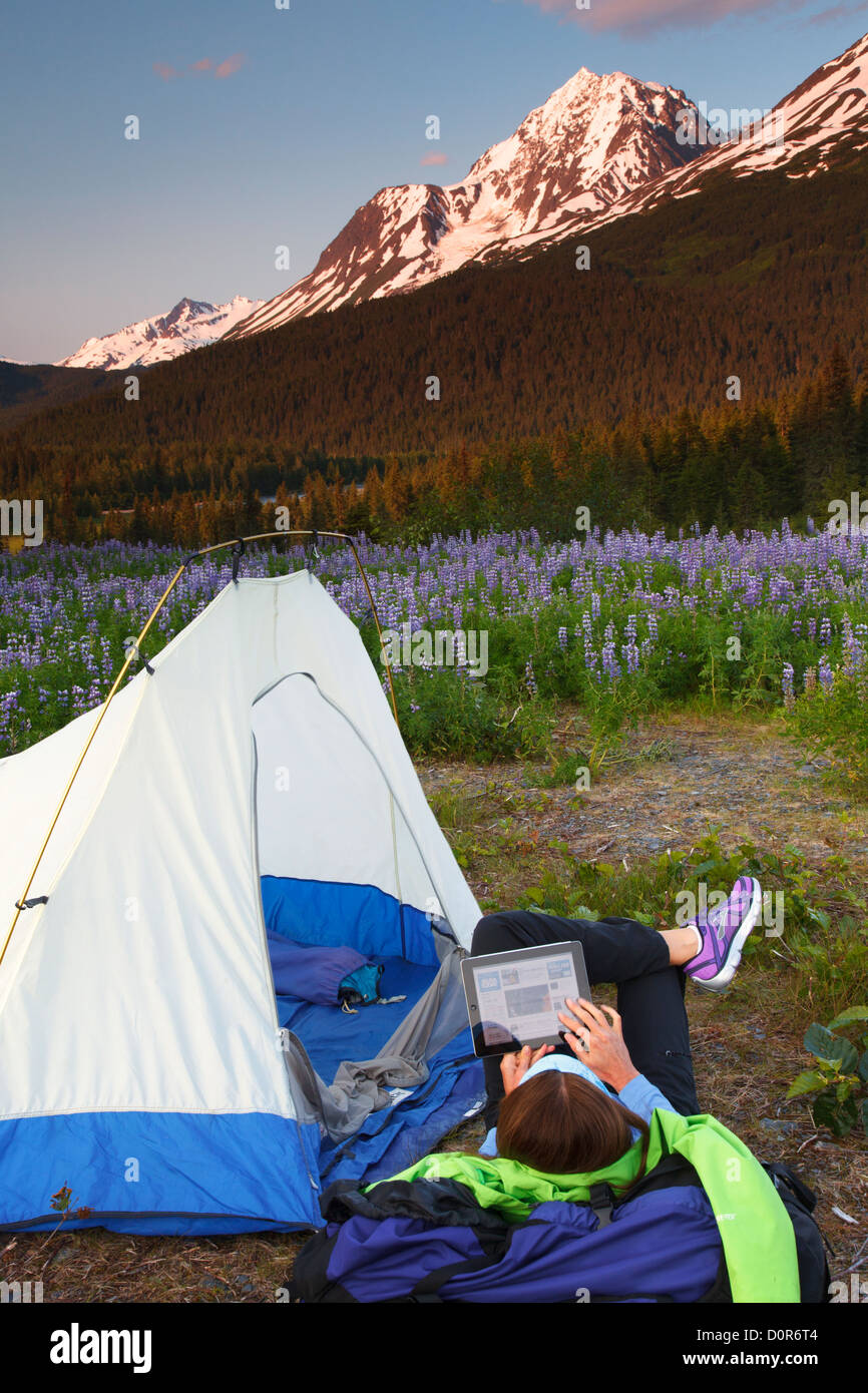 Reading an ipad while camping in the Chugach National Forest, Alaska ...