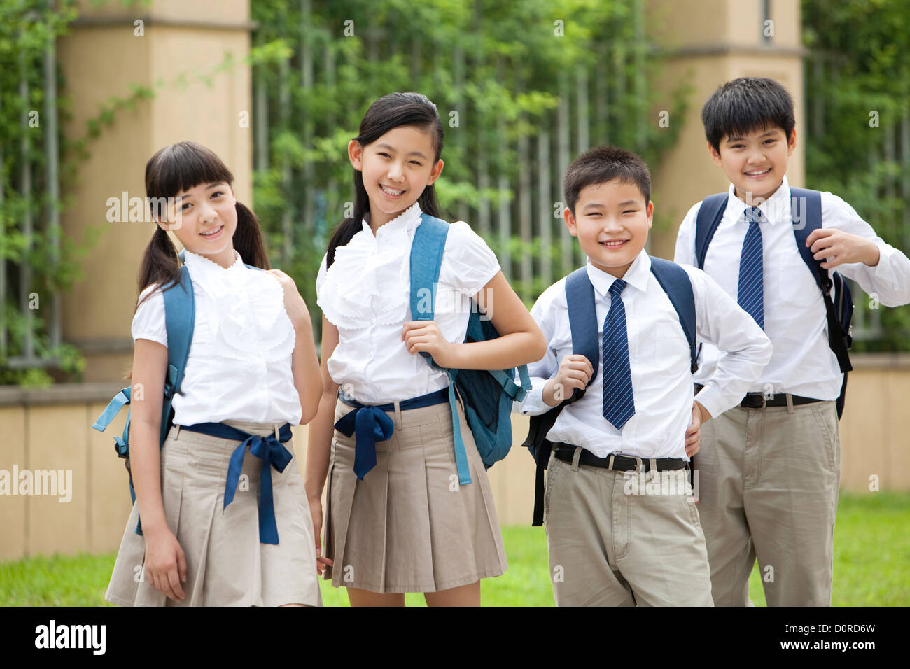 Portrait of cute schoolchildren in uniform at school yard Stock Photo ...