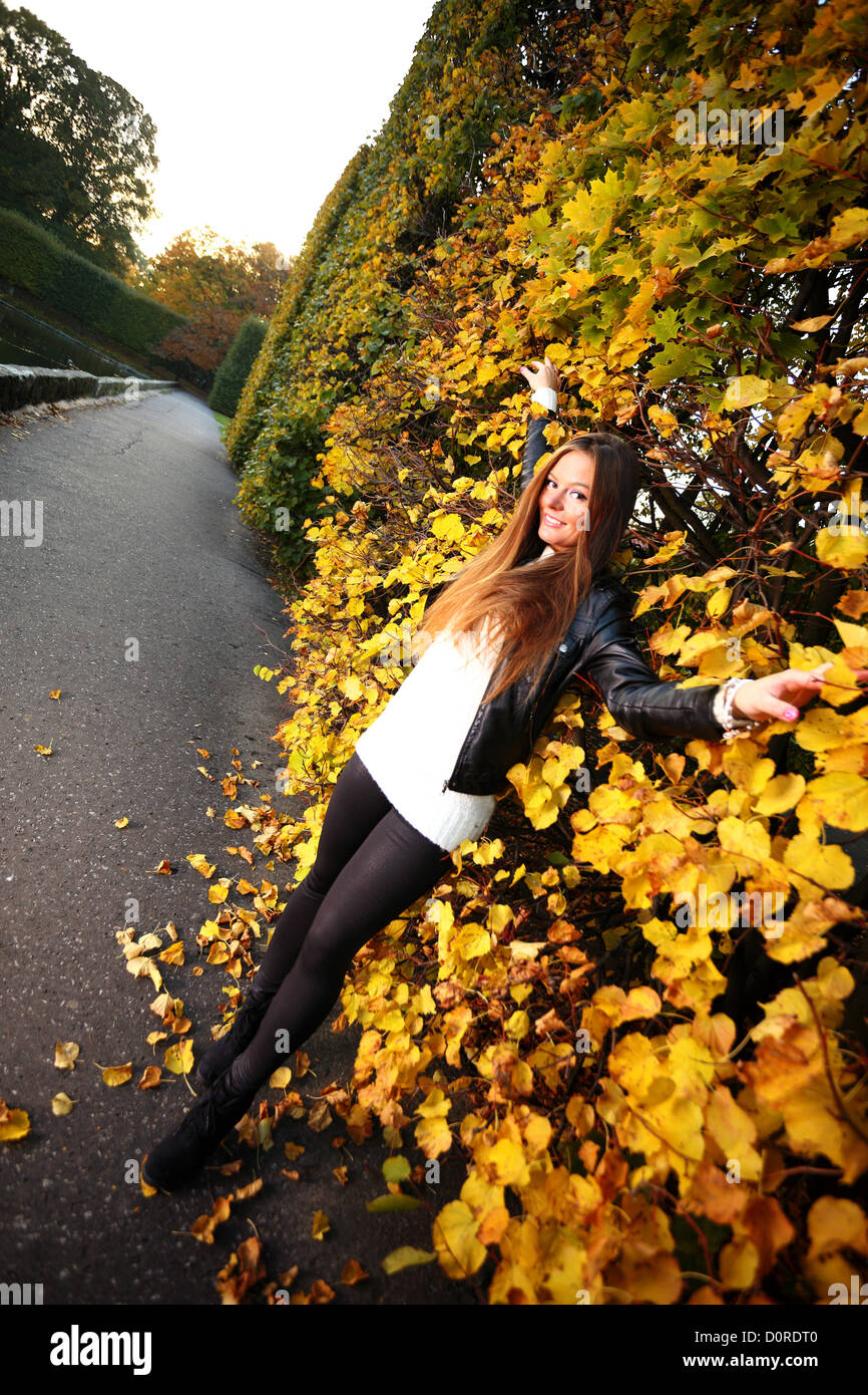 Young woman stand autumn leaves fall yellow green girl garden ...