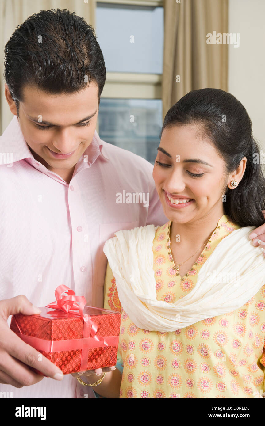 Man giving a present to a woman Stock Photo - Alamy