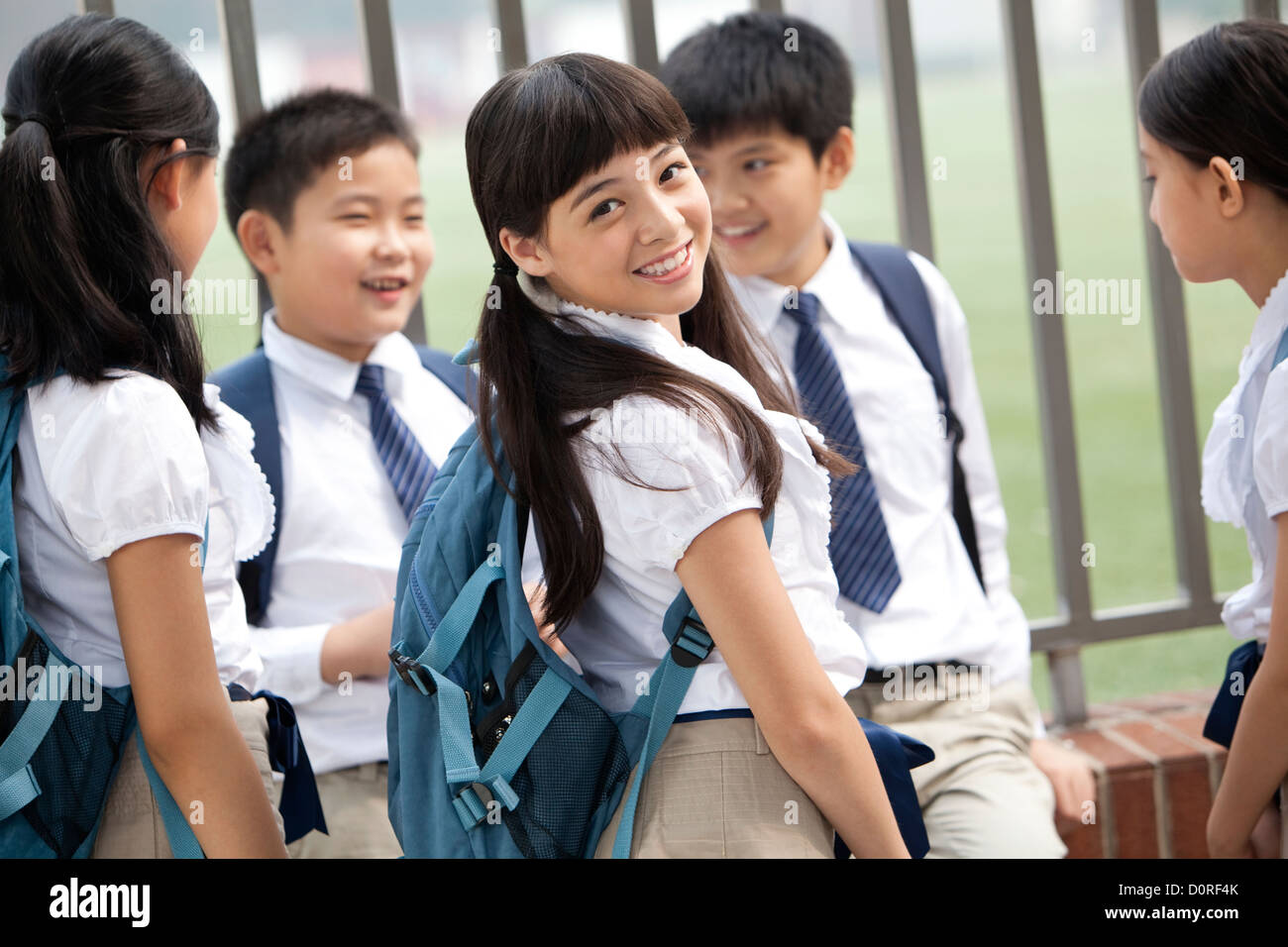 Happy schoolgirl in uniform with her friends outdoors Stock Photo - Alamy