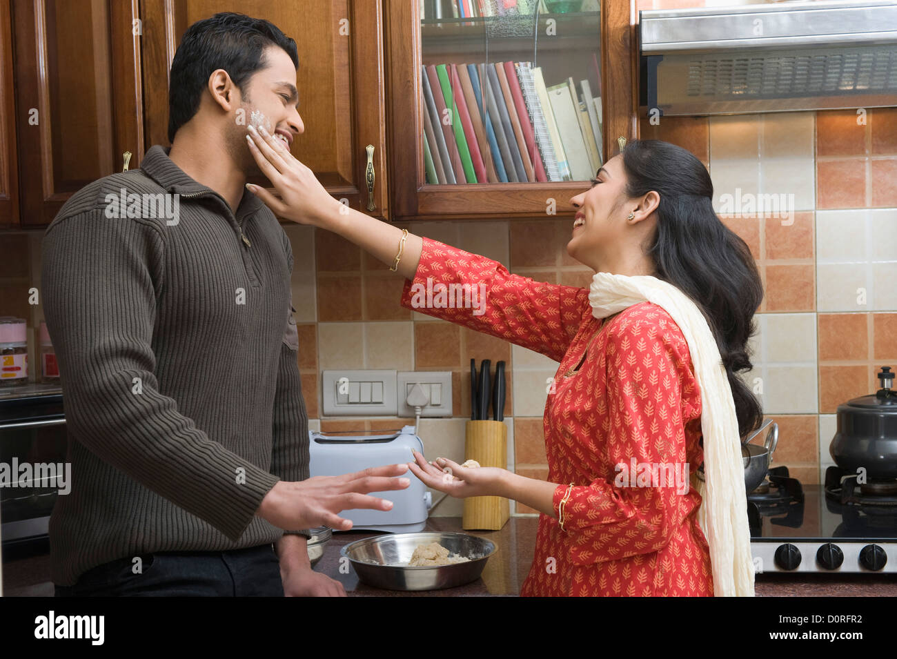 Couple having fun in the kitchen while cooking Stock Photo - Alamy