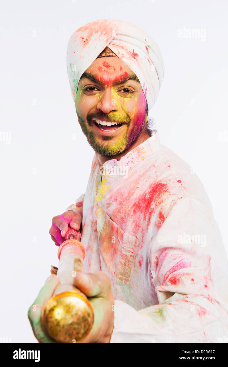 Portrait of a man playing Holi with a pichkari Stock Photo - Alamy