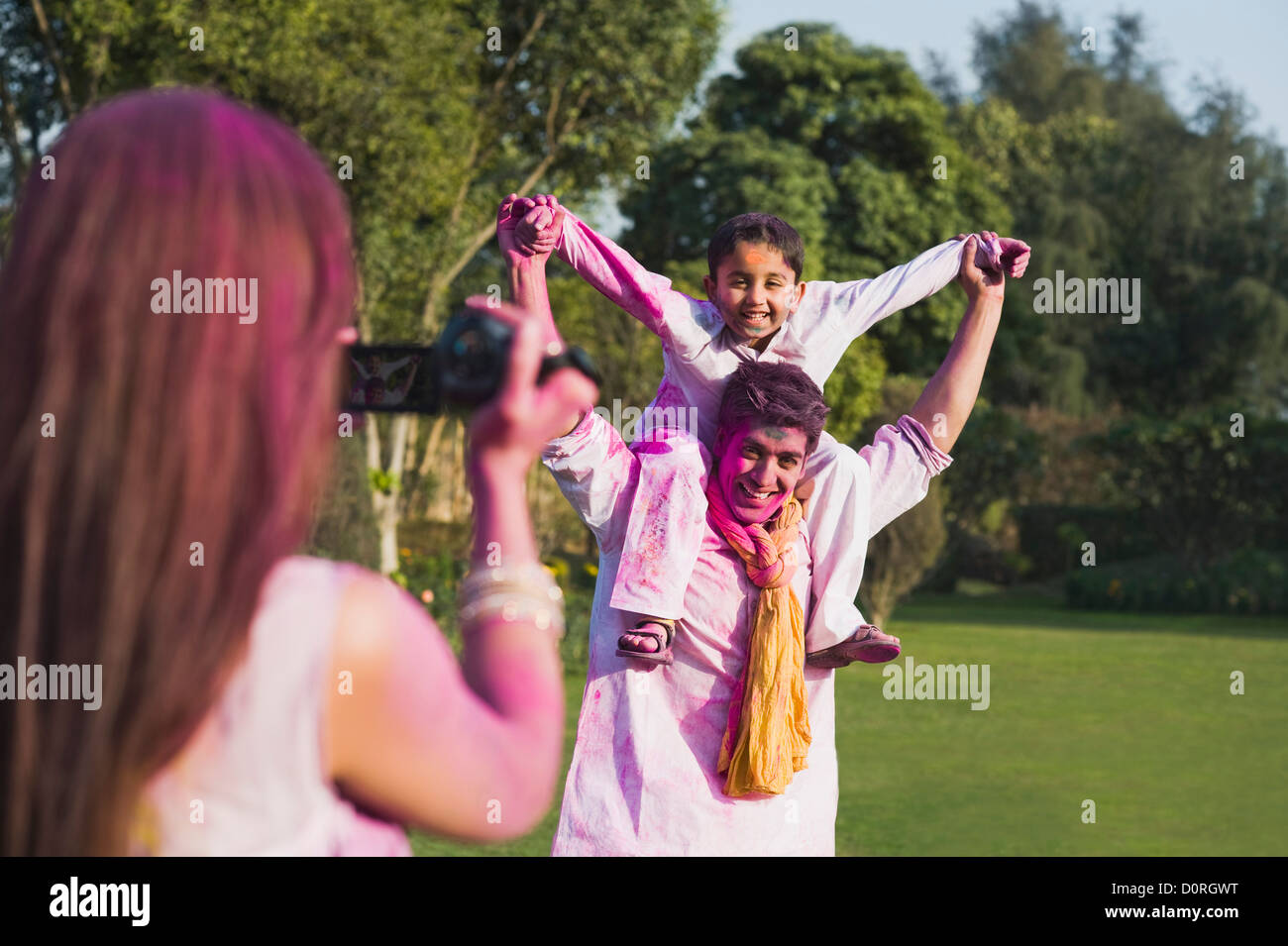 Woman filming her family with a video camera on Holi Stock Photo - Alamy