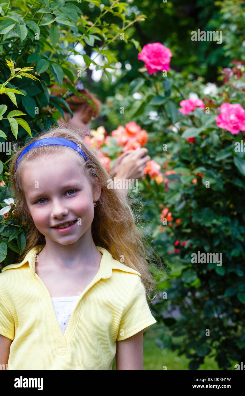 Portrait girl among the blossoming rose bushes Stock Photo - Alamy