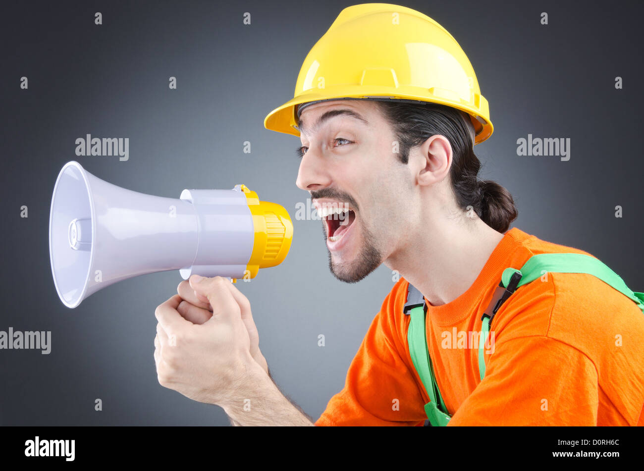 Construction worker with loudspeaker in studio Stock Photo - Alamy