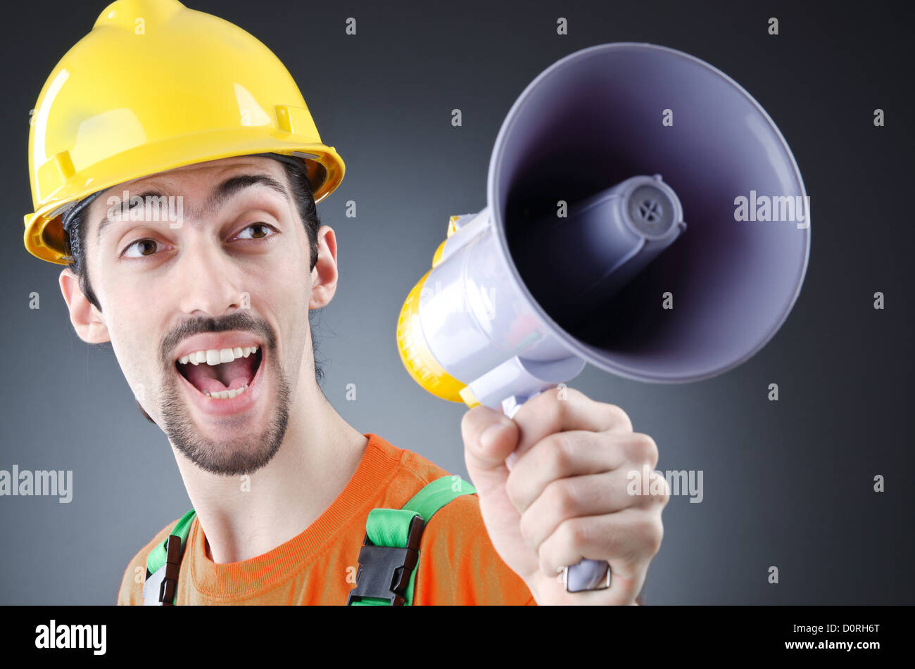 Construction worker with loudspeaker in studio Stock Photo - Alamy