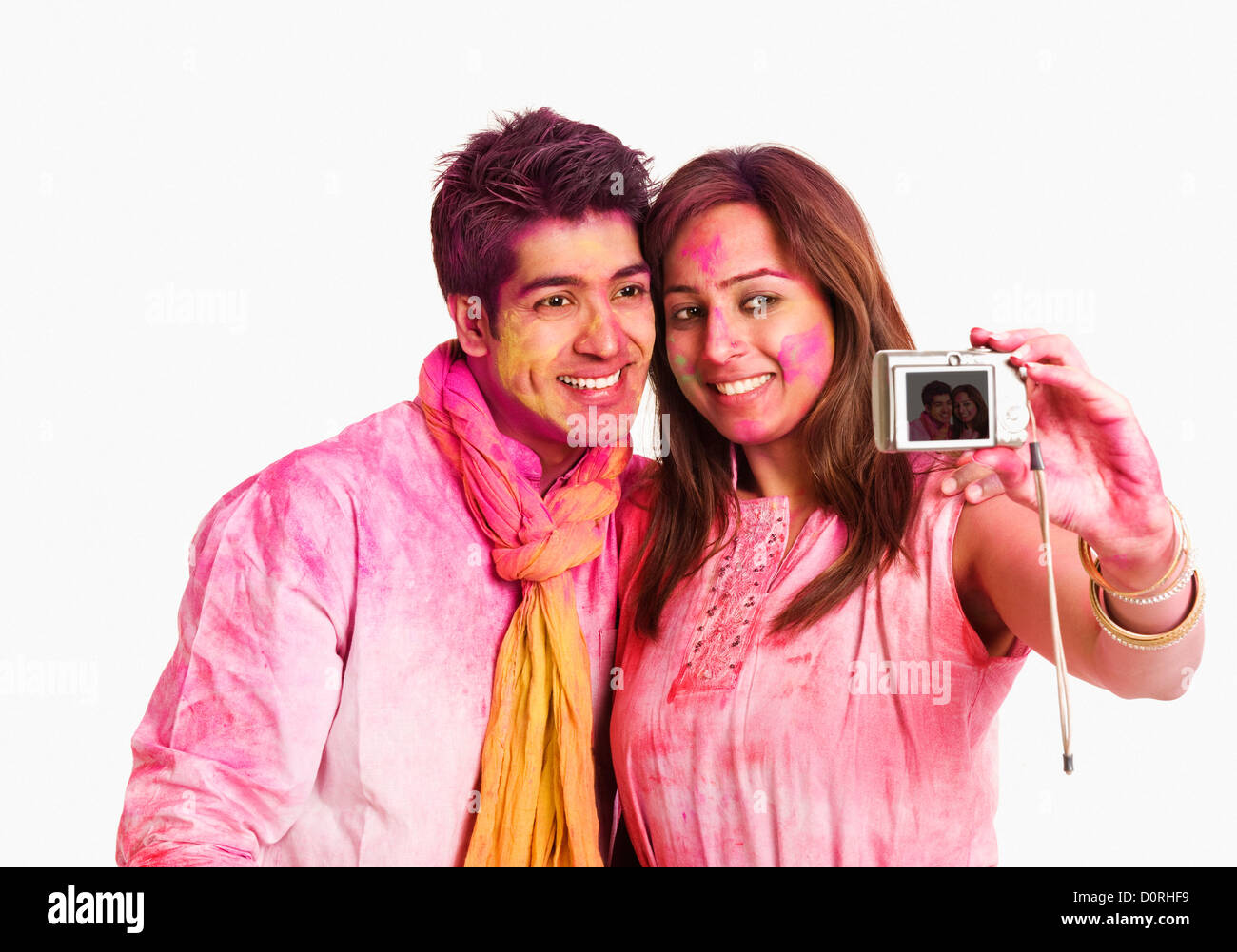 Couple taking a picture of themselves with a camera on Holi Stock Photo ...