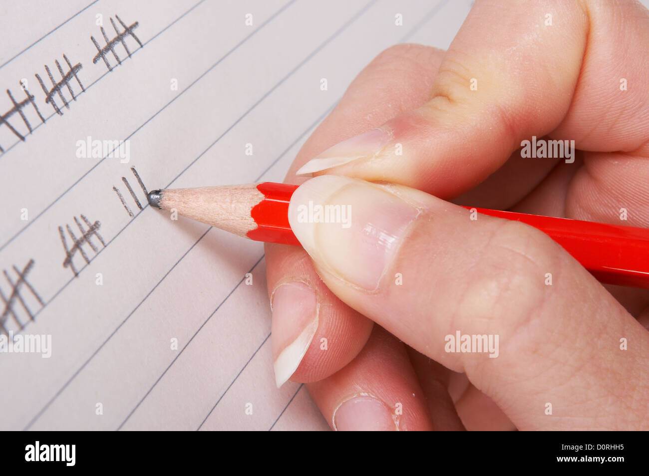 Hand holding a pencil and counting scores Stock Photo - Alamy