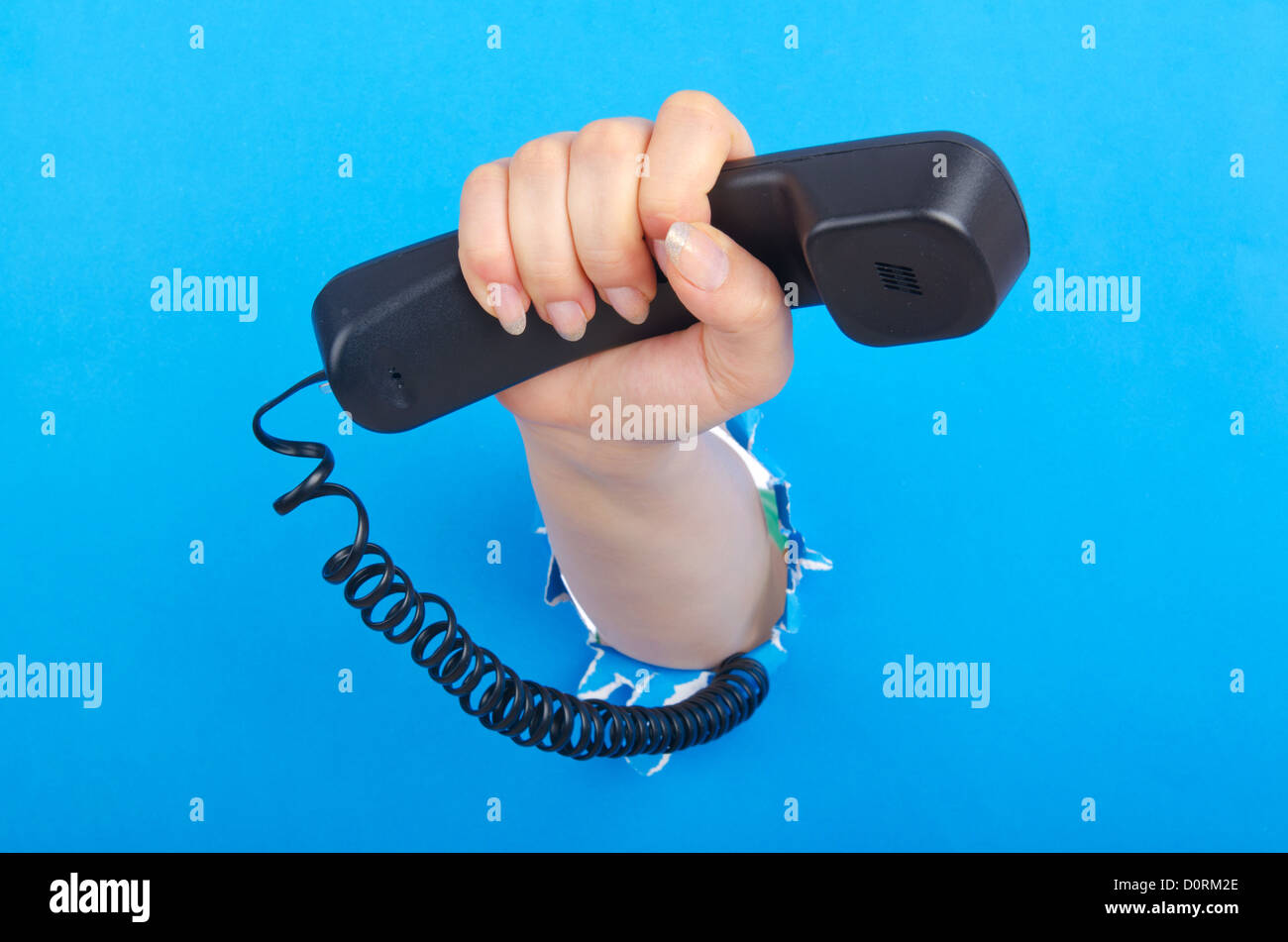 Hand with phone out of paper hole Stock Photo - Alamy