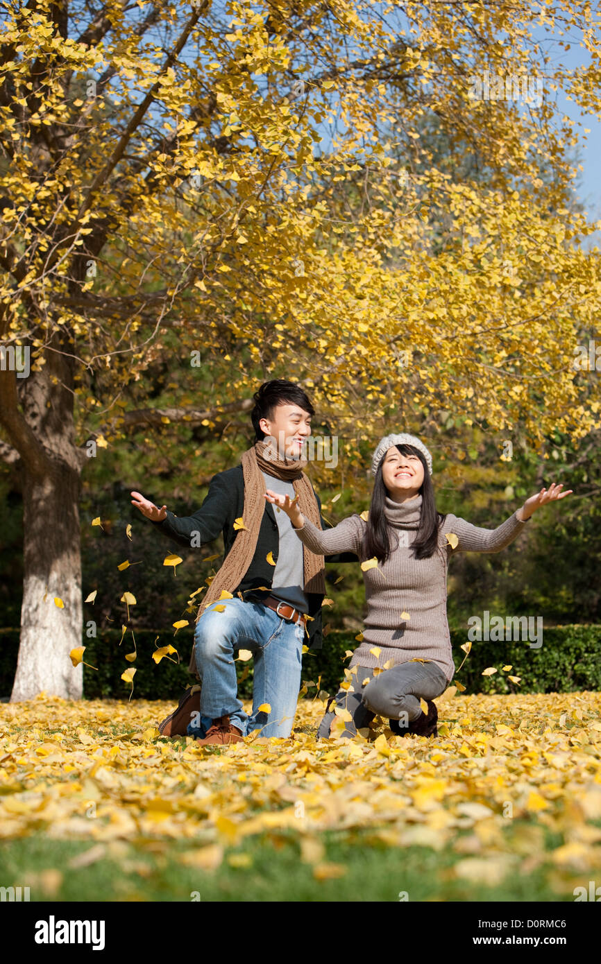 Happy young couple enjoying the dancing fallen leaves in the fall Stock ...