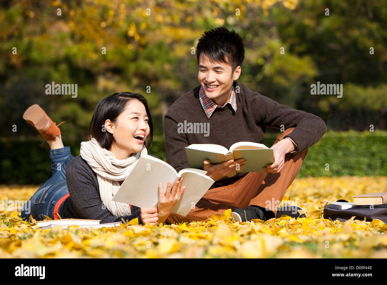 Merry college couple with books in the golden autumn on campus Stock ...