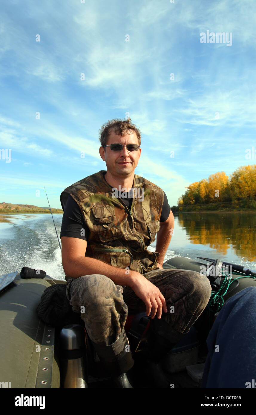 man on inflatable boat with motor Stock Photo - Alamy