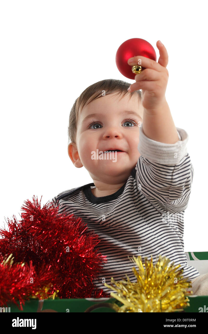 Eight months baby inside a box showing a christmas ball in a white ...