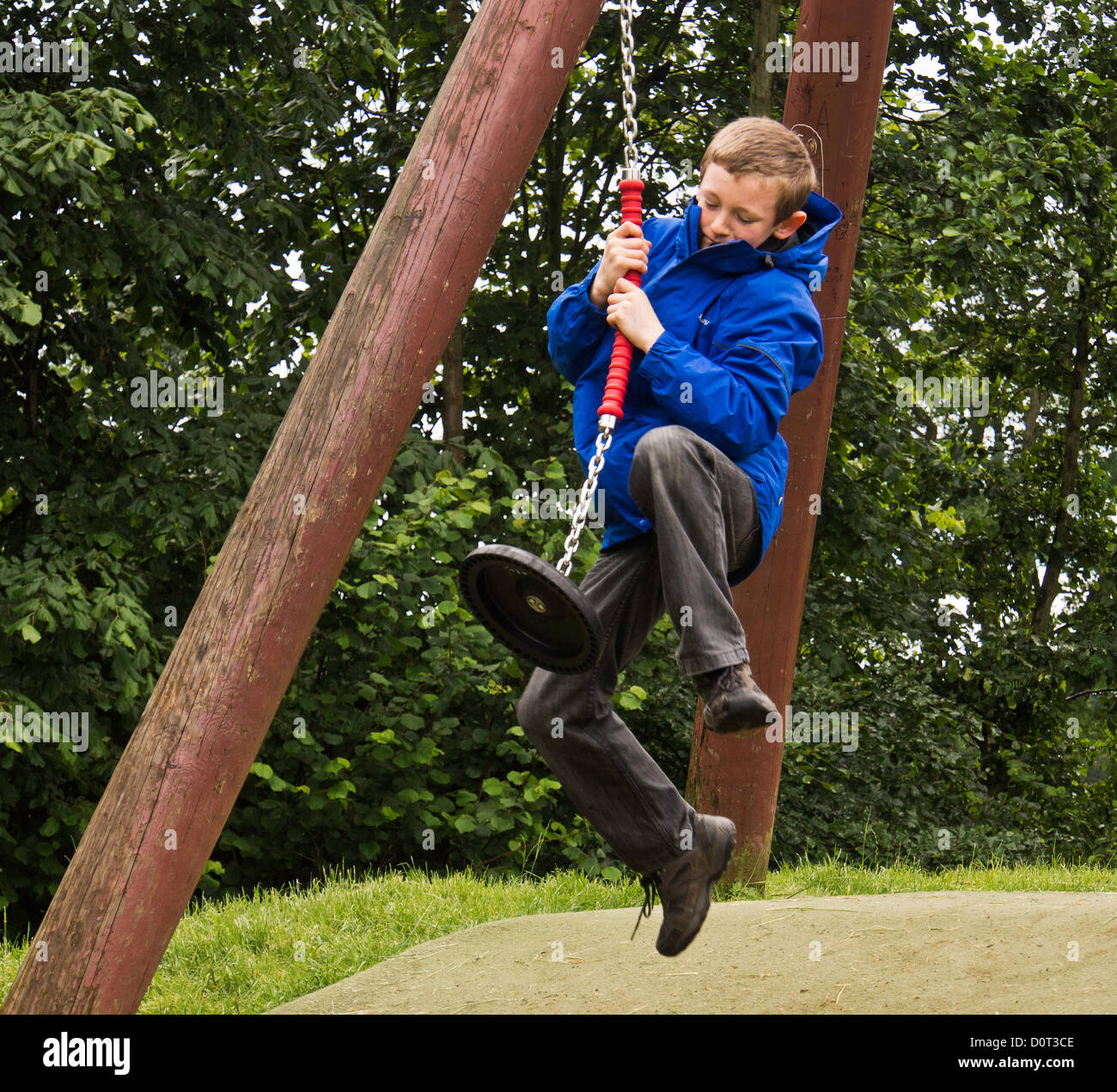 Teenage boy playing on zip wire at local park Stock Photo - Alamy