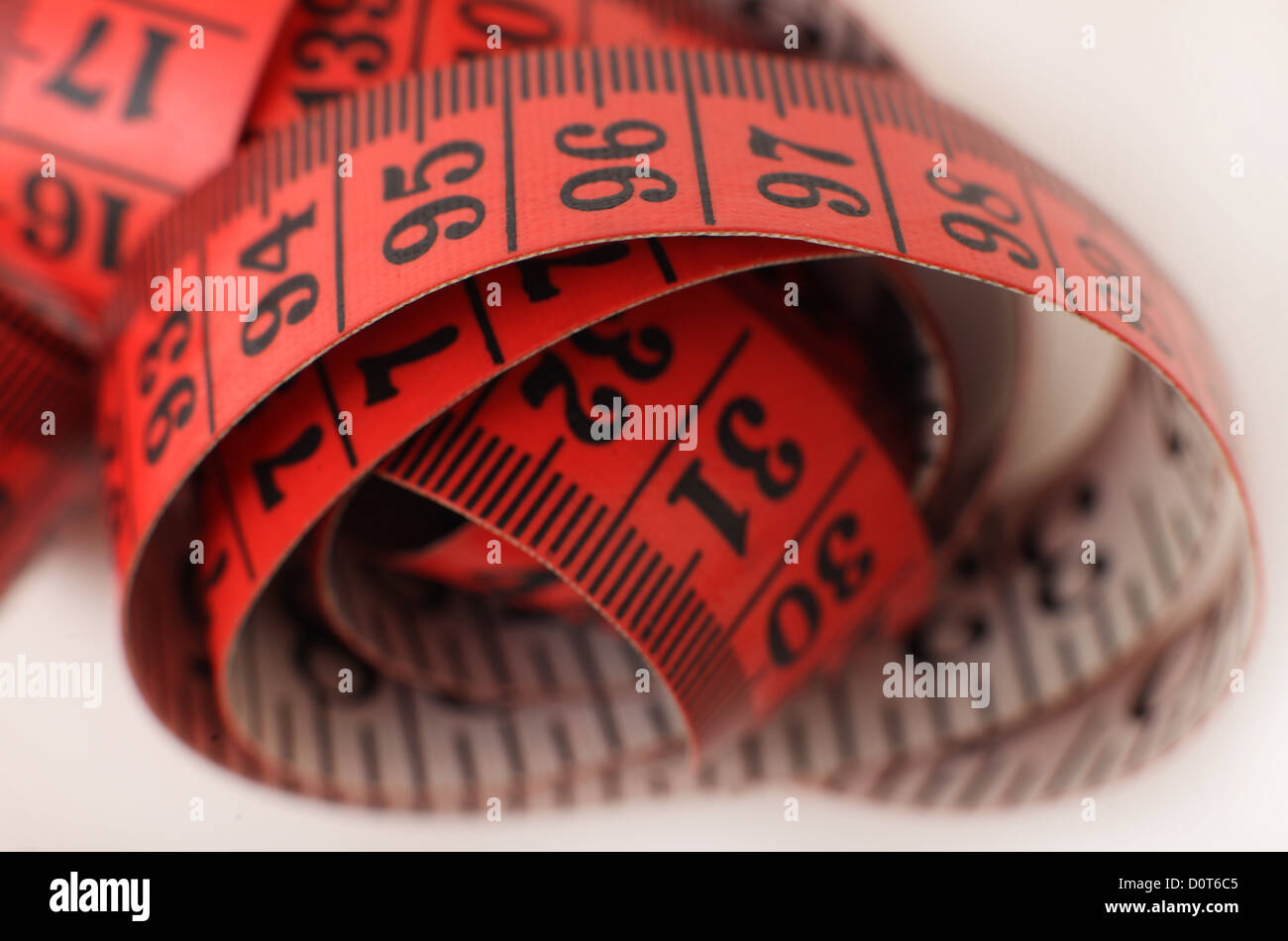 A ROLLED UP RED TAPE MEASURE. PHOTOGRAPHED BY JAMIE MANN Stock Photo ...