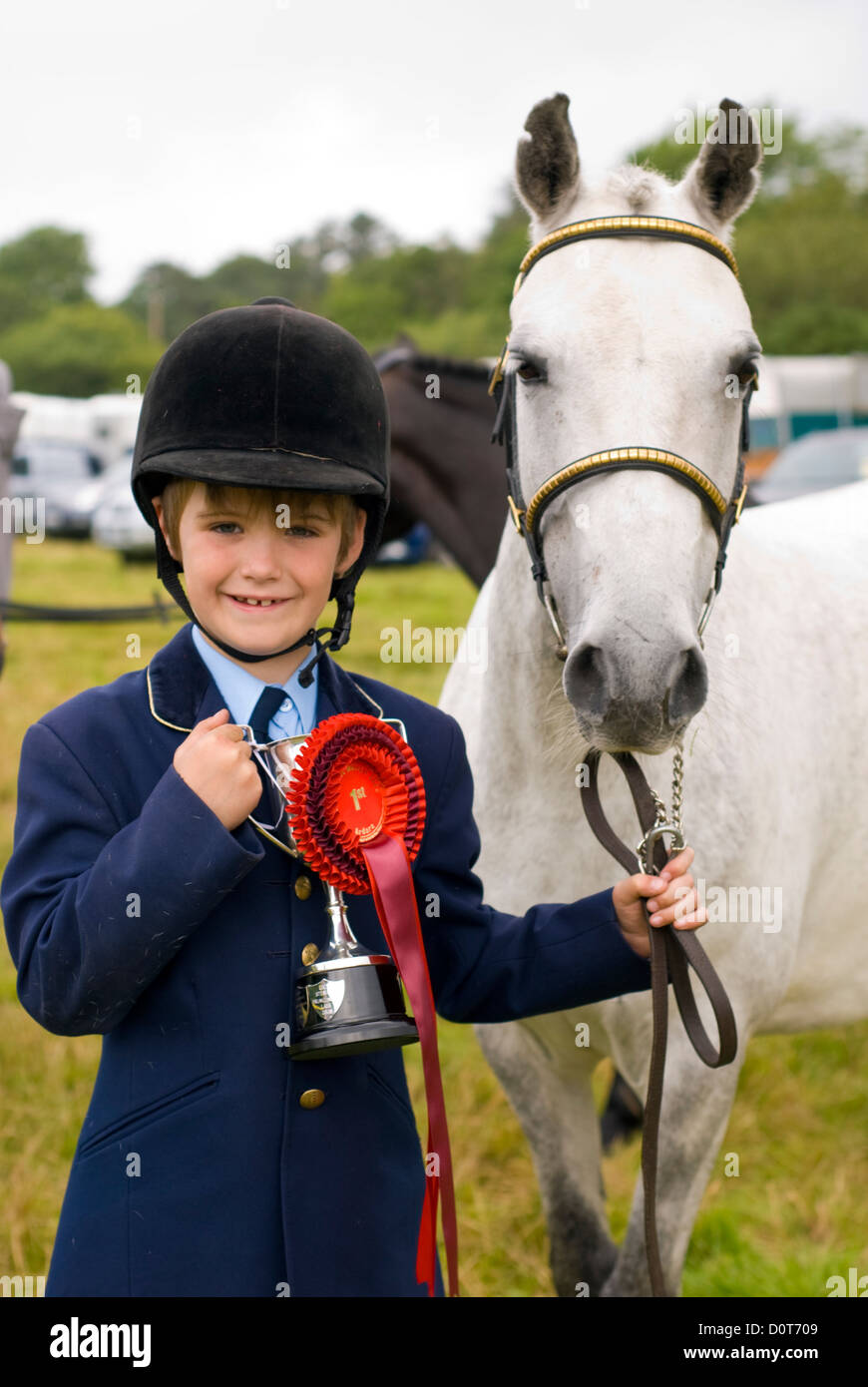 Proud winner a young boy shows off his winning first prize rosette and ...
