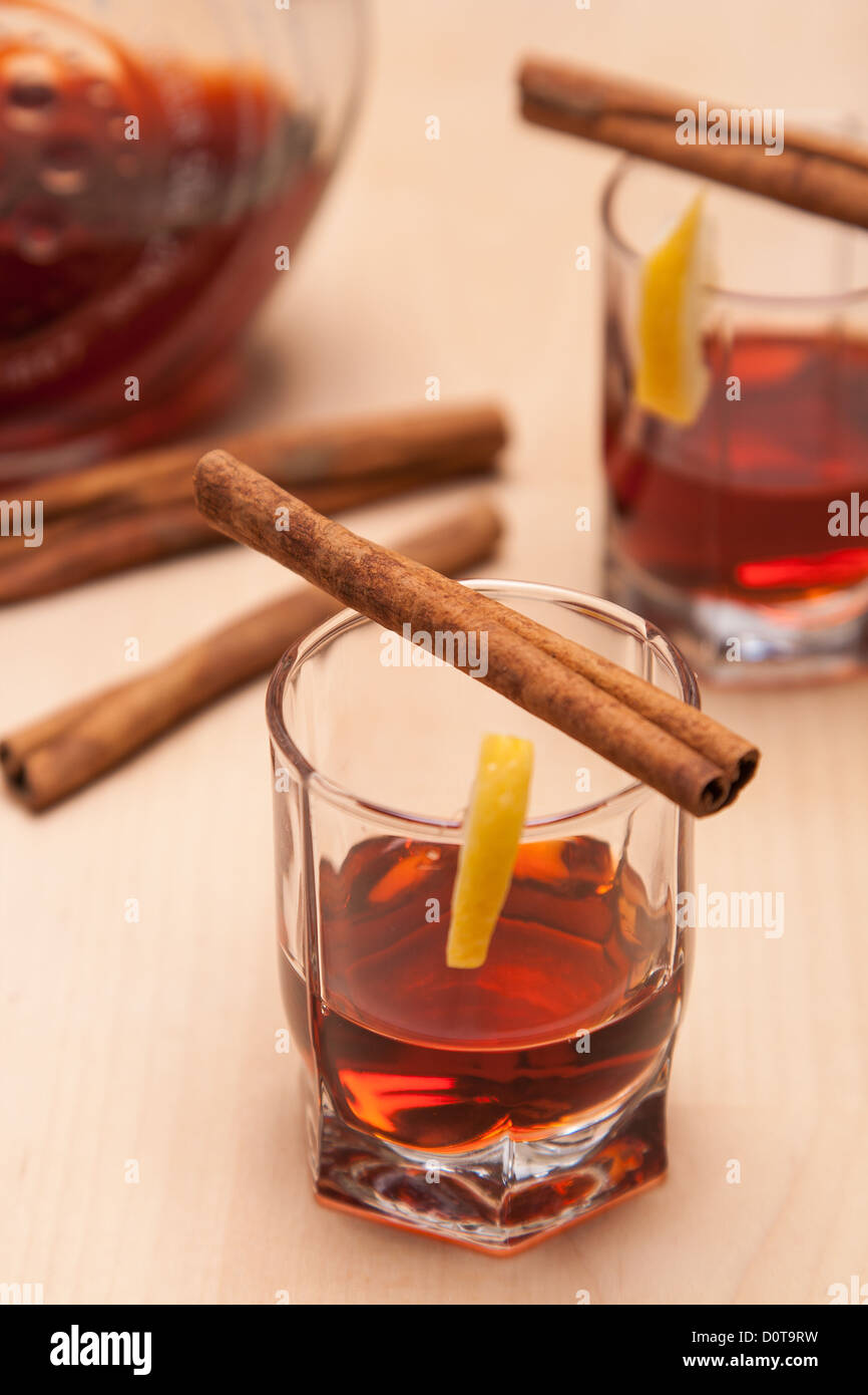 glass heating red liqueur with cinnamon sticks on wood table Stock ...