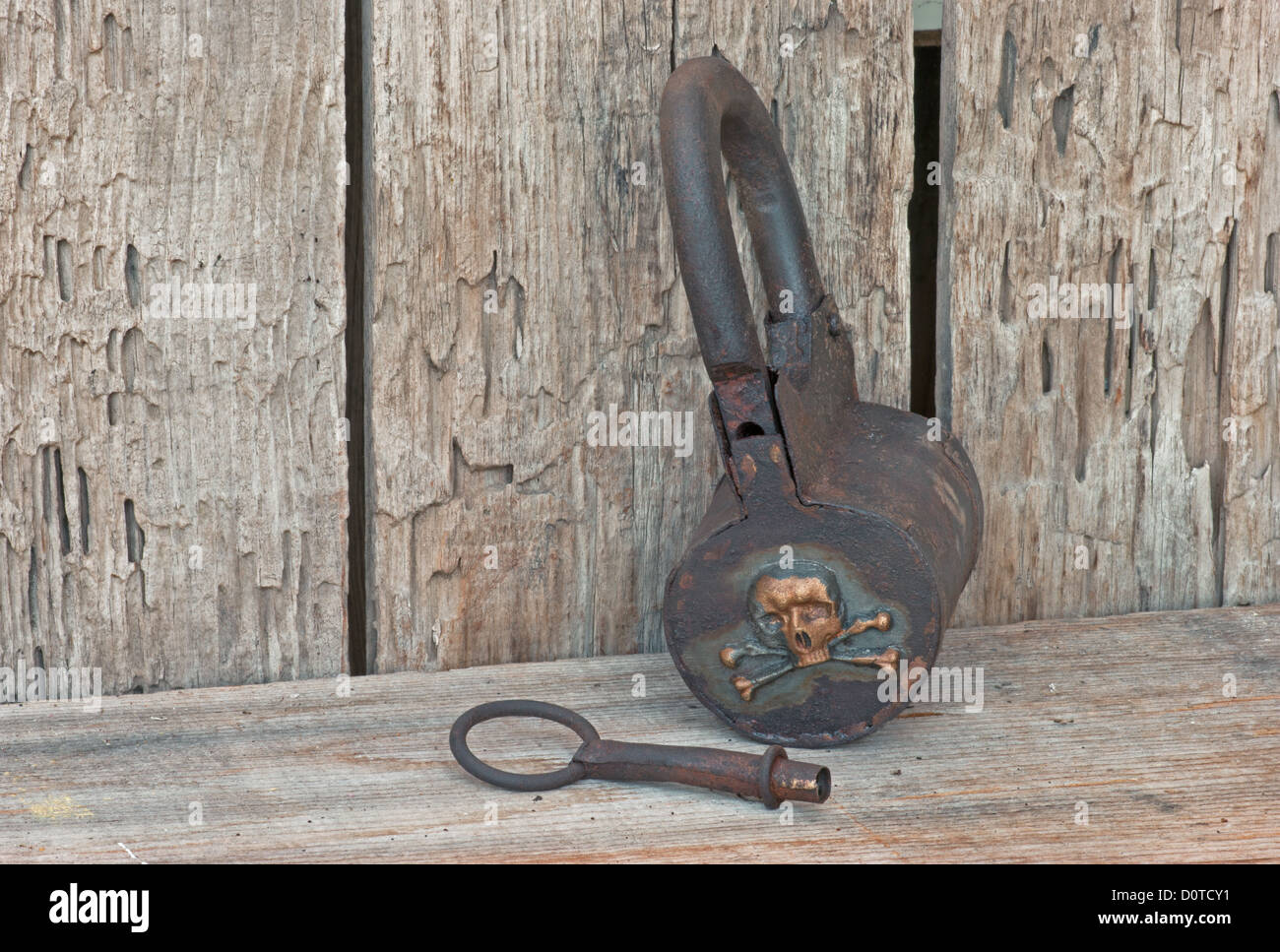 Pirate treasure barrel lock and key resting on weathered wood shelf ...