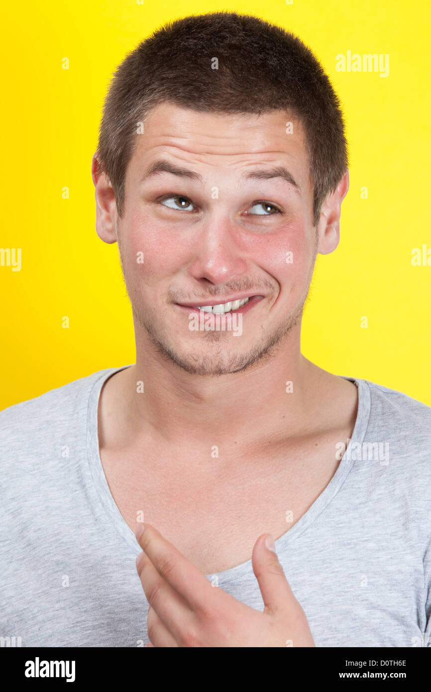 Man with a cheeky face on yellow background Stock Photo - Alamy