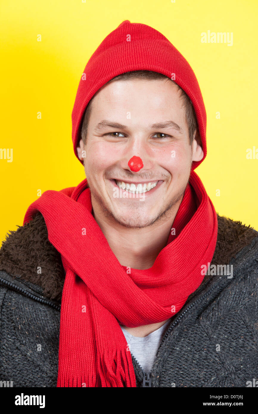 Handsome young man with red scarf and cap with red nose and a smile ...
