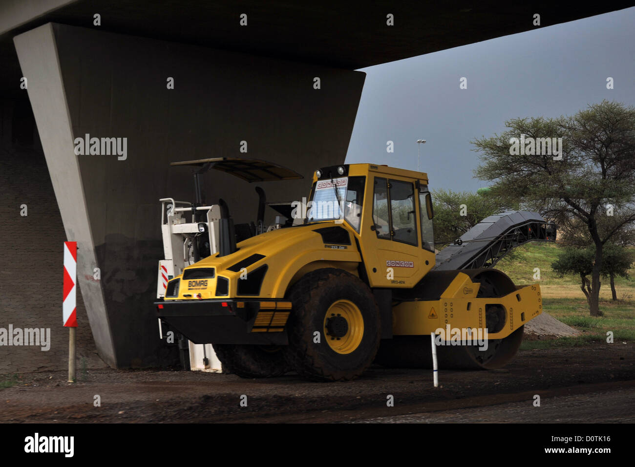 Roadwork equipment parked under a highway bridge Stock Photo - Alamy