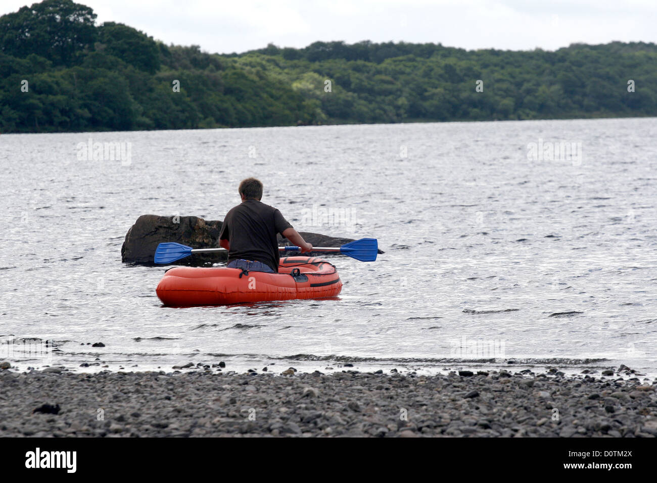 Lone guy in a rubber dingy on Loch Lomond in Scotland Stock Photo - Alamy