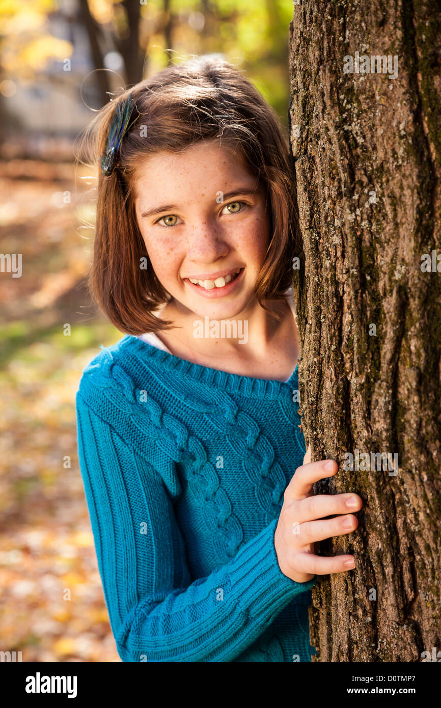 Young Girl Peeking around Tree, USA Stock Photo - Alamy