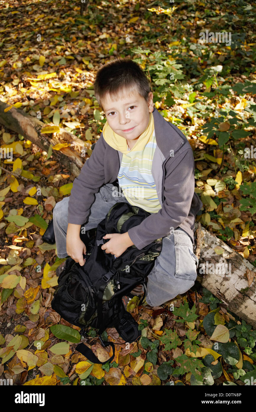 Positive boy sitting on log Stock Photo - Alamy