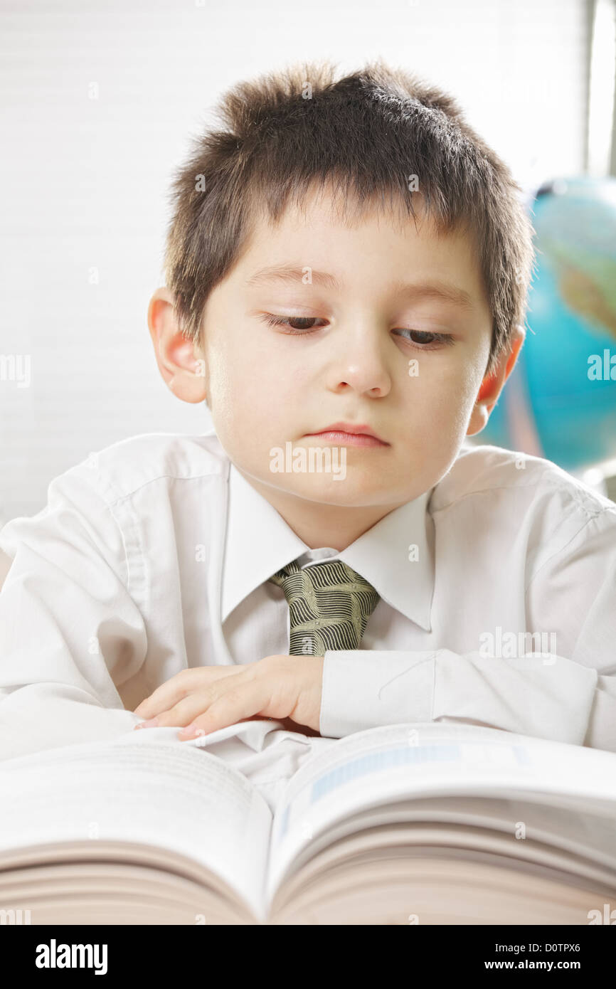 Serious kid reading book Stock Photo - Alamy