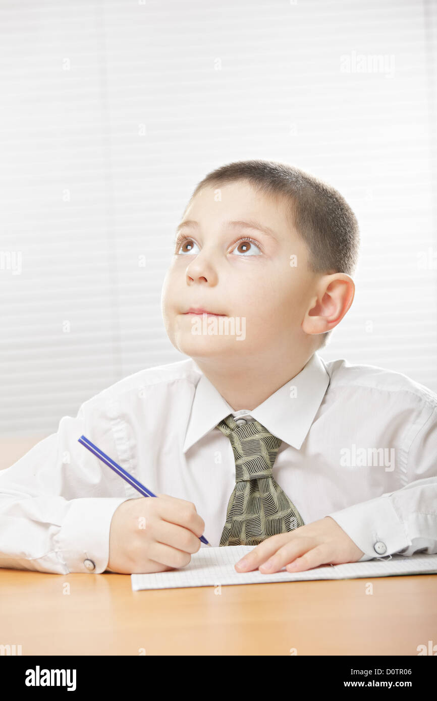Boy at desk looking up Stock Photo - Alamy