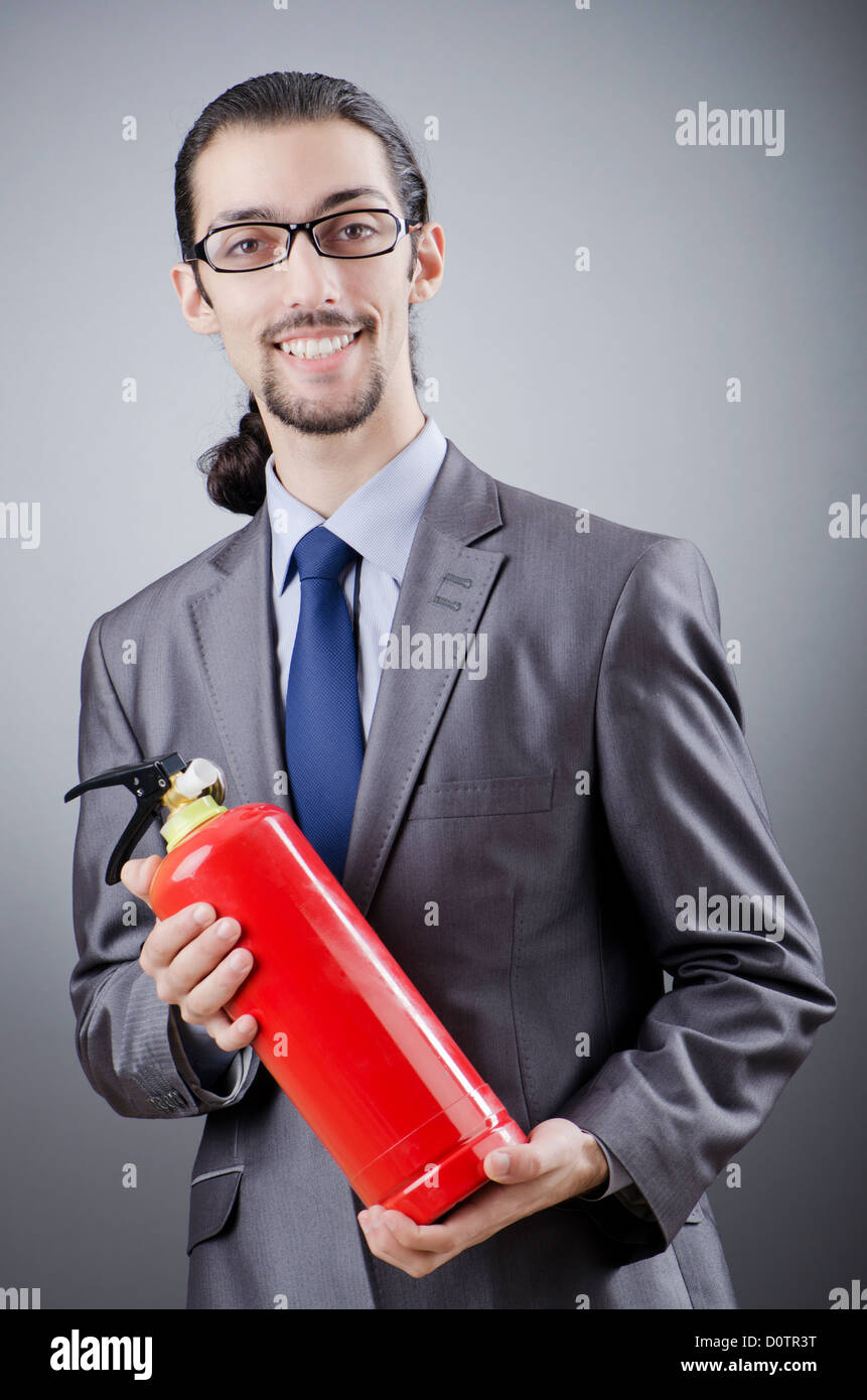 Man with fire extinguisher in firefighting concept Stock Photo - Alamy
