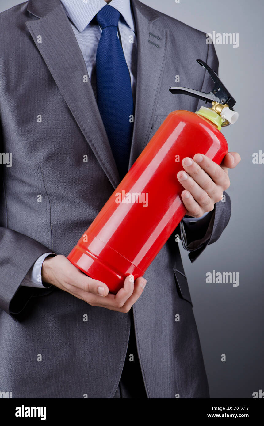 Man with fire extinguisher in firefighting concept Stock Photo - Alamy