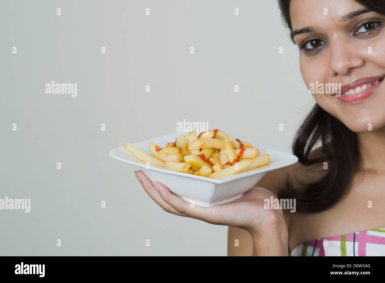 Woman holding French fries in a bowl Stock Photo - Alamy
