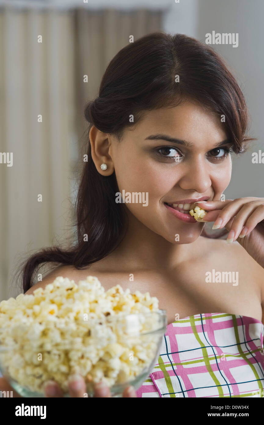 Portrait of a woman eating popcorn Stock Photo - Alamy