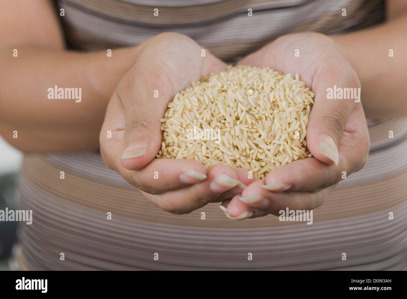 Mid section view of a woman holding brown rice Stock Photo - Alamy